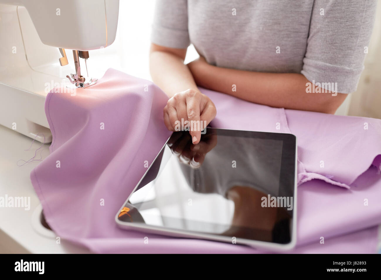 tailor with sewing machine, tablet pc and fabric Stock Photo - Alamy