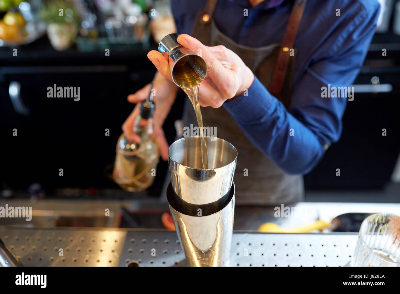 bartender with shaker preparing cocktail at bar Stock Photo - Alamy