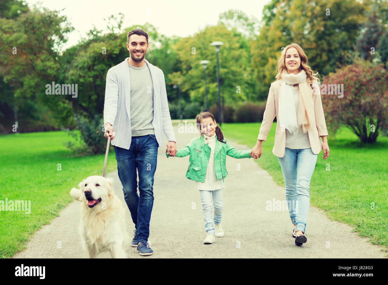 happy family with labrador retriever dog in park Stock Photo - Alamy