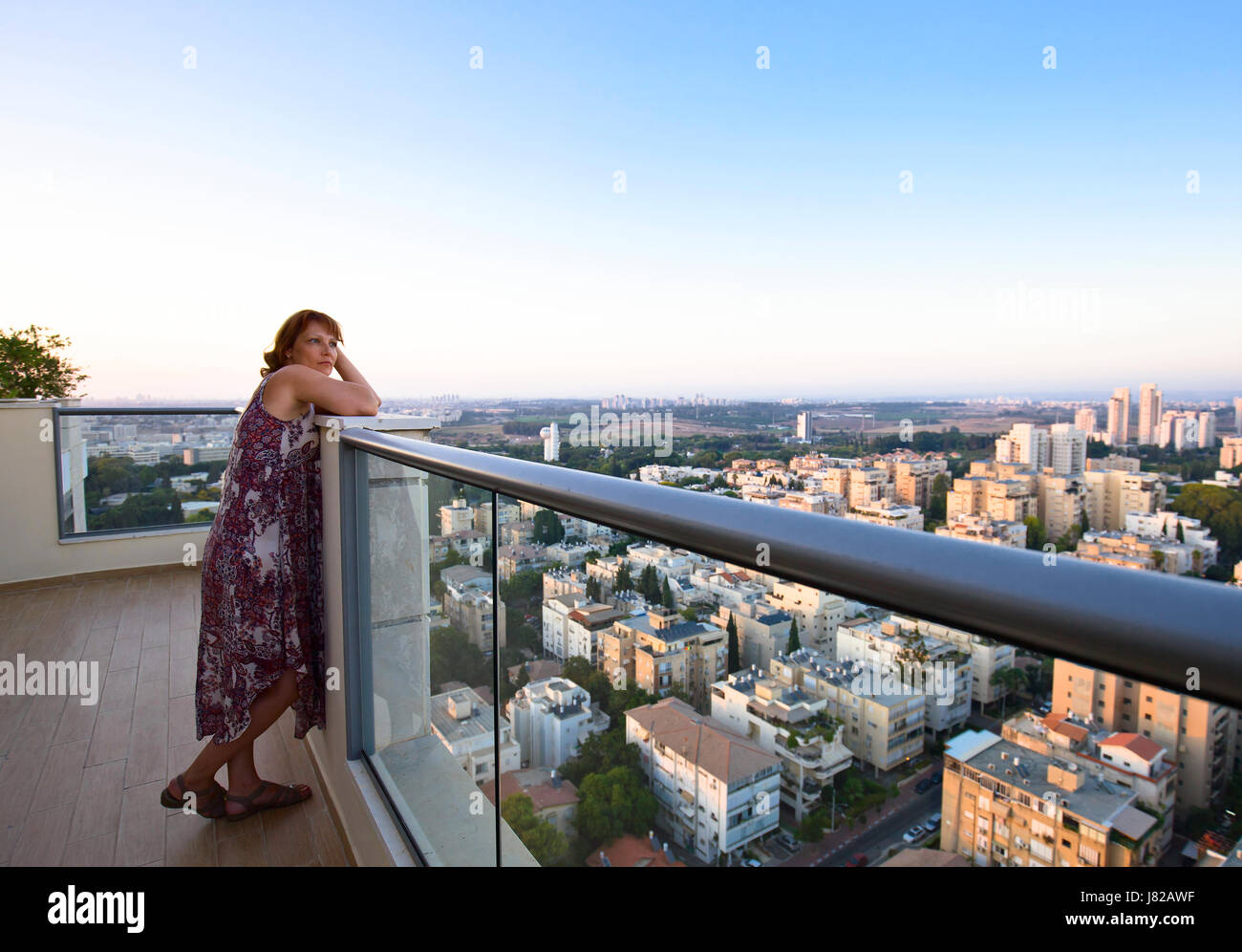 Woman on a balcony in downtown of modern city Stock Photo - Alamy