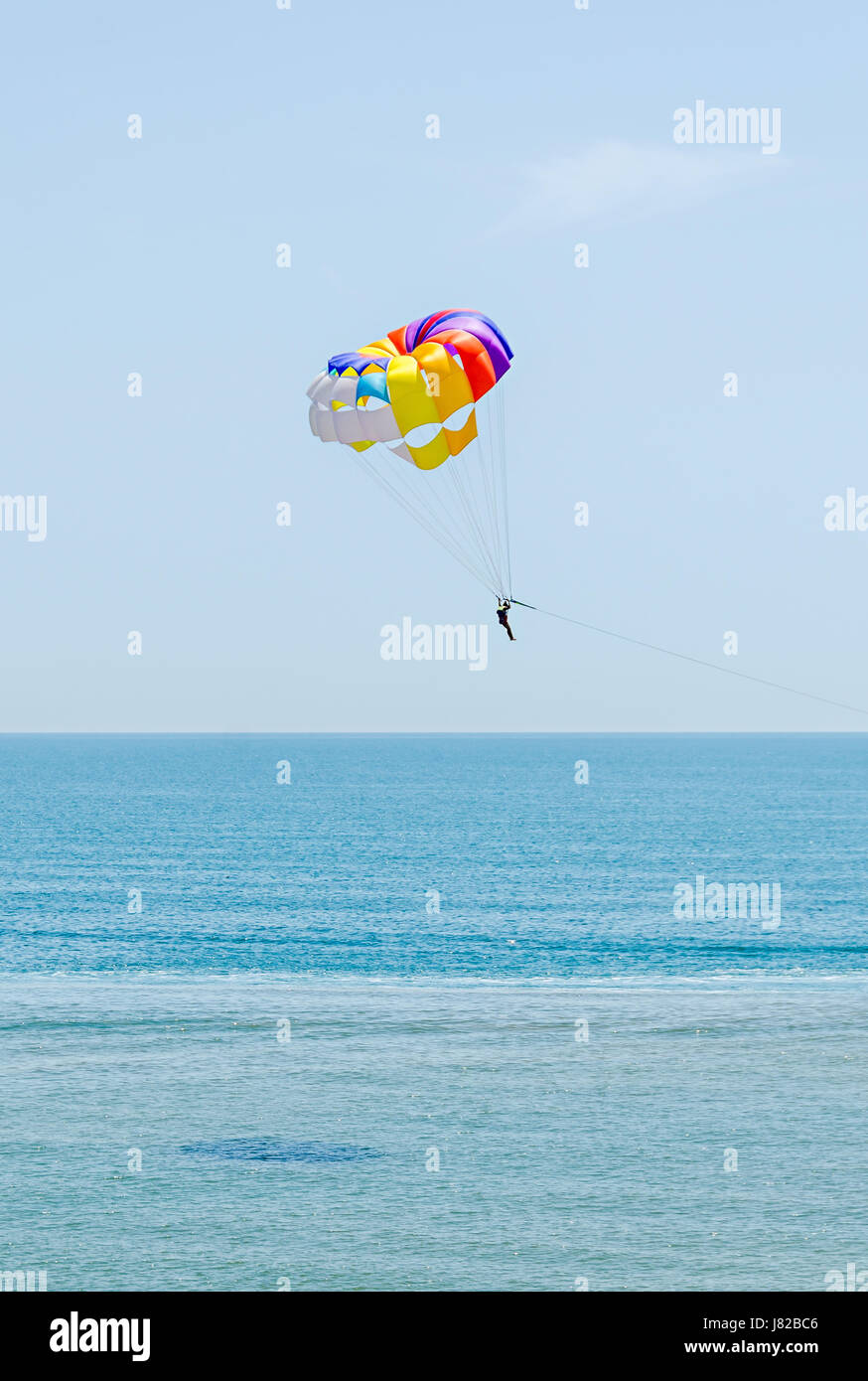 Colored parasail wing in the blue sky, Parasailing also known as ...