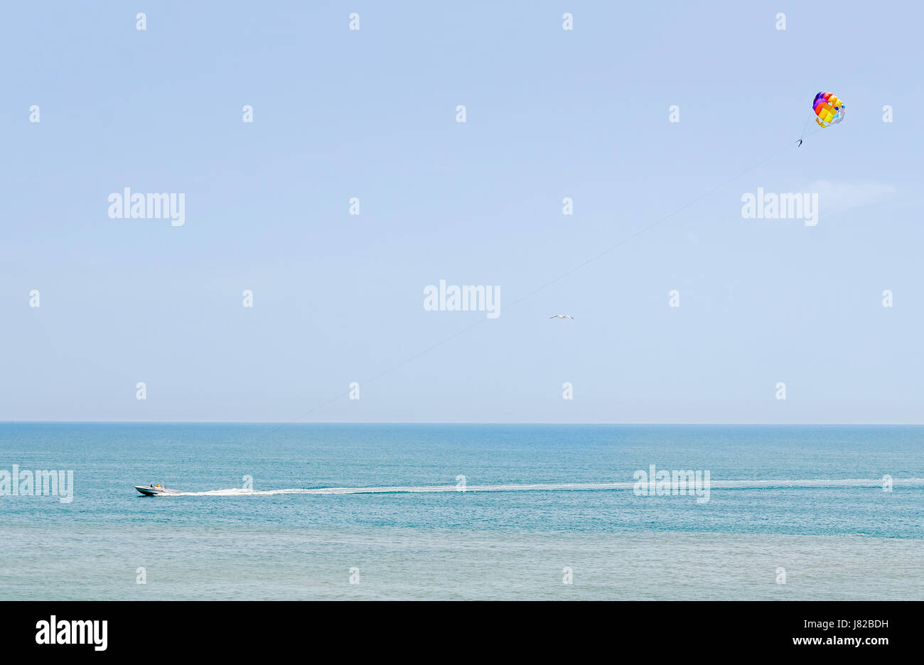 Colored parasail wing in the blue sky, Parasailing also known as ...
