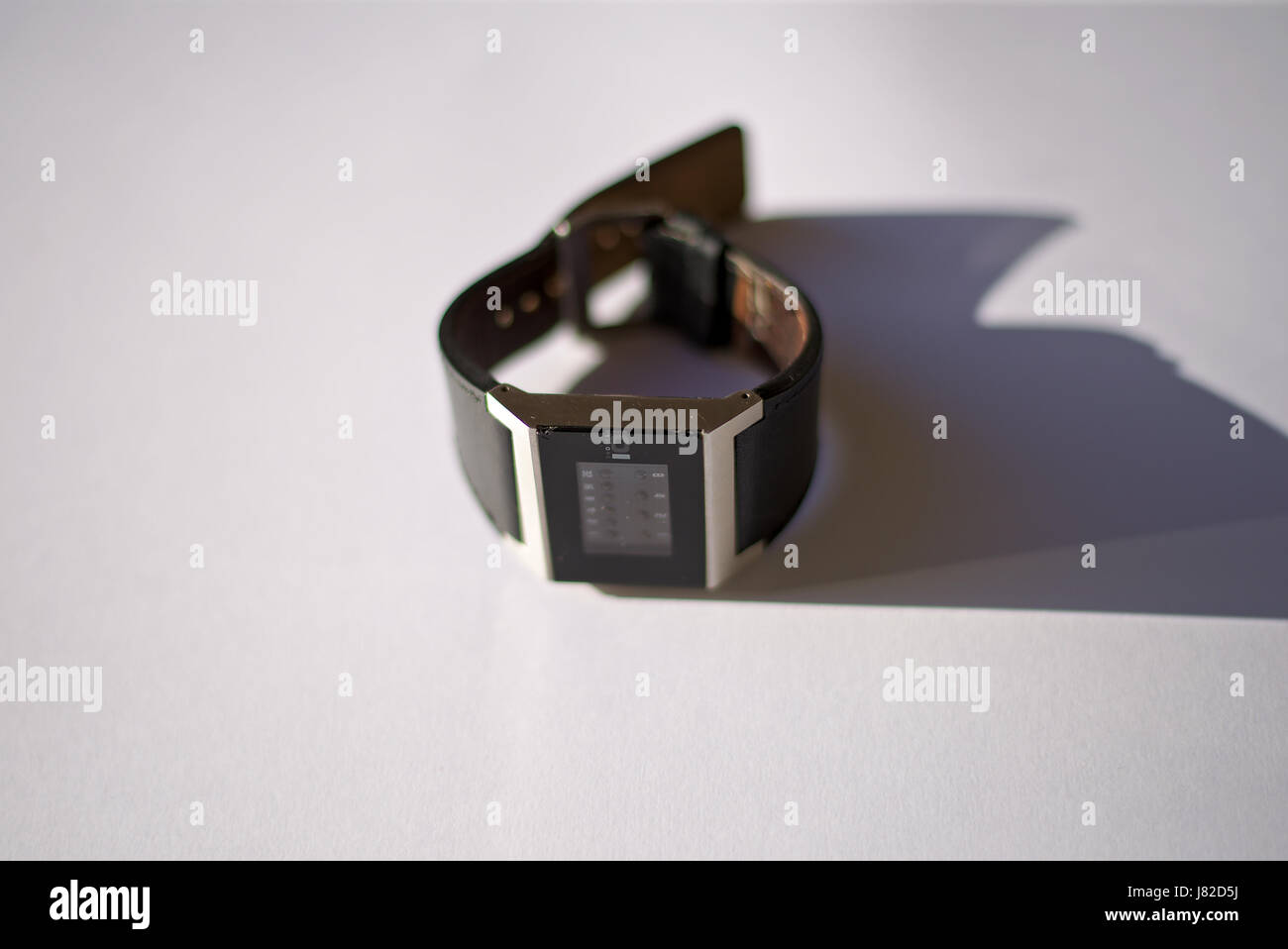 A modern binary watch with a leather strap on a clear background with ...