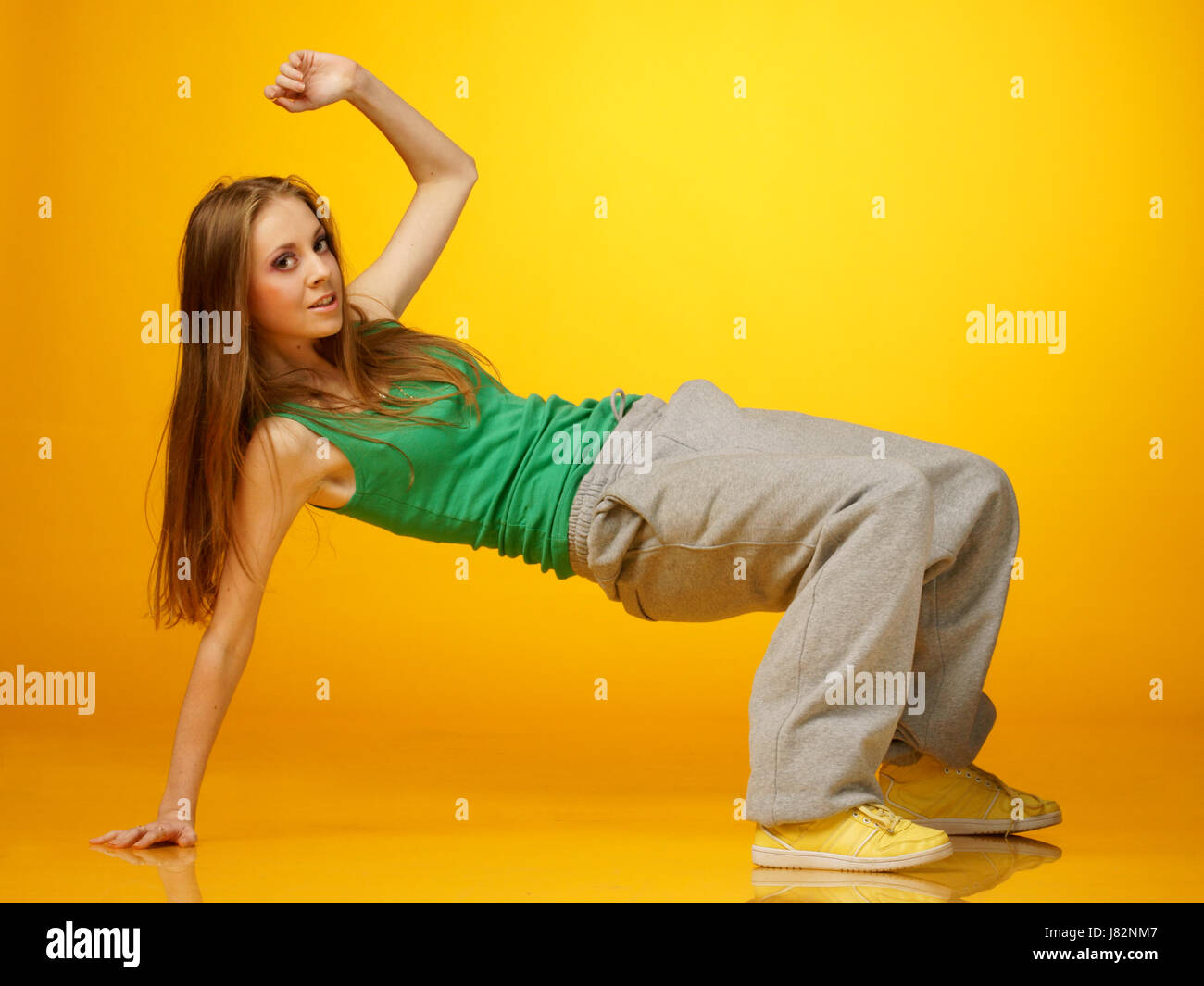female breakdancer posing on yellow background Stock Photo - Alamy