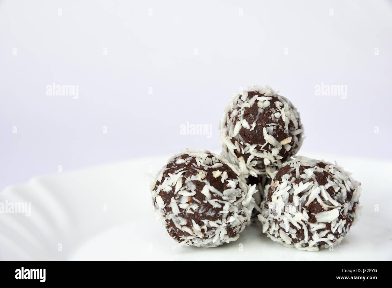Christmas sweets on a plate - Rum balls in coconut. Traditional ...