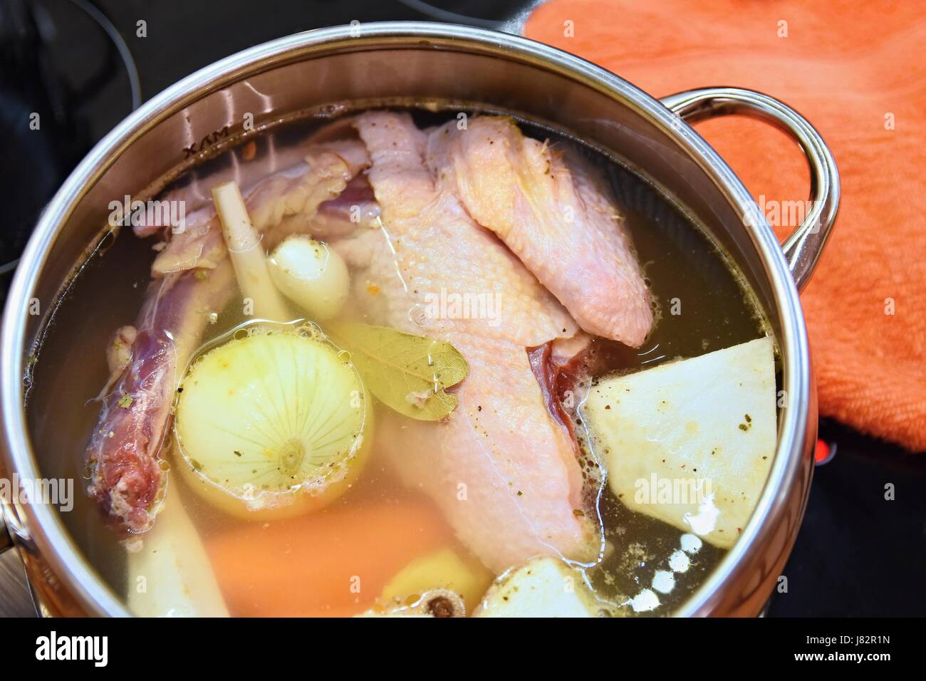 Preparing homemade chicken soup - broth. Pot on the stove in the ...