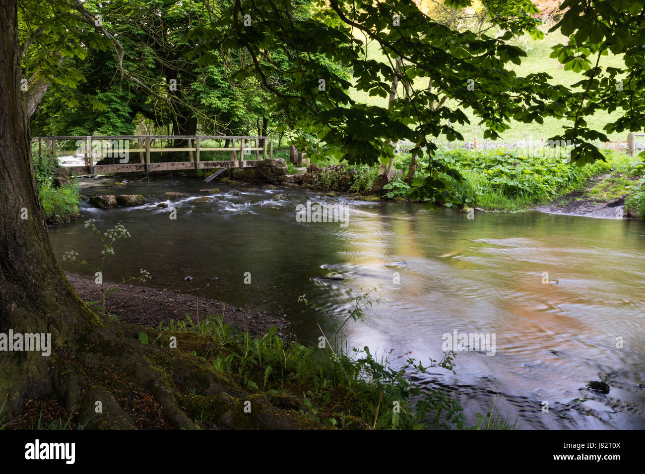 Long exposure of the River Dove flowing under the footbridge across ...
