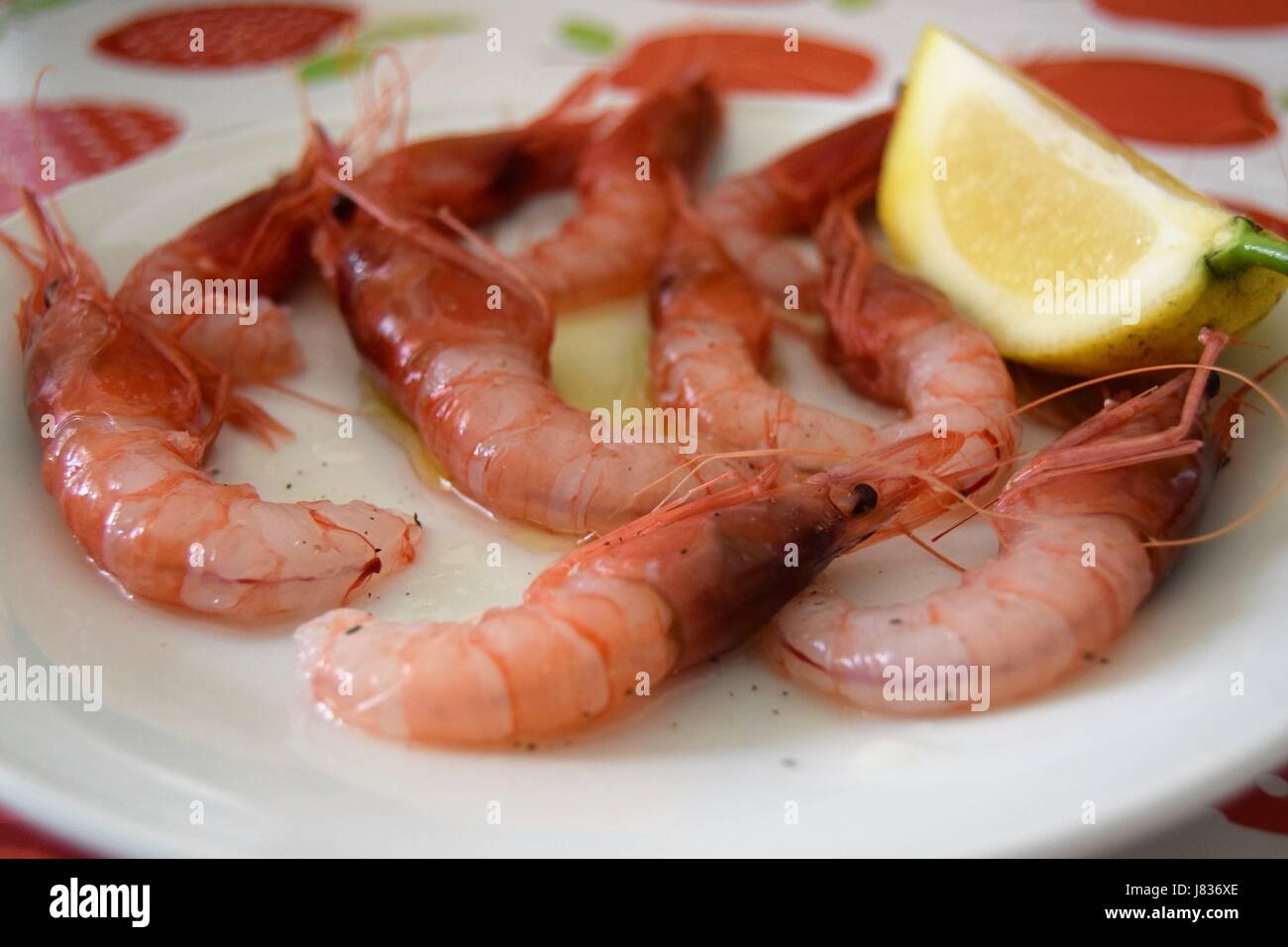 Eating raw red prawn dressed with oil and lemon juice Stock Photo - Alamy