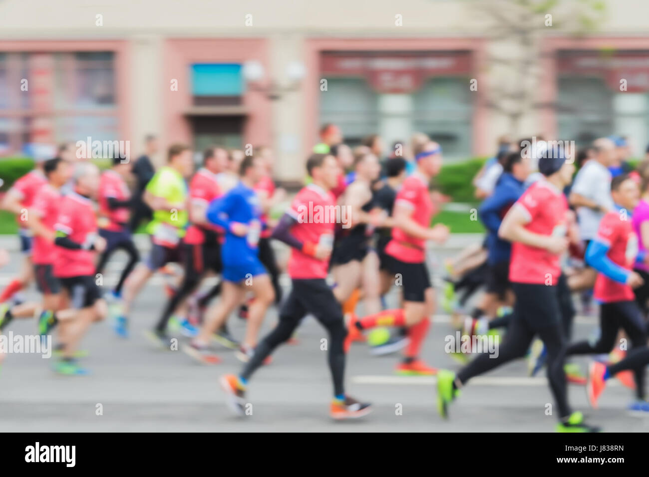 Large group of running athletes on the street, city marathon, blur ...