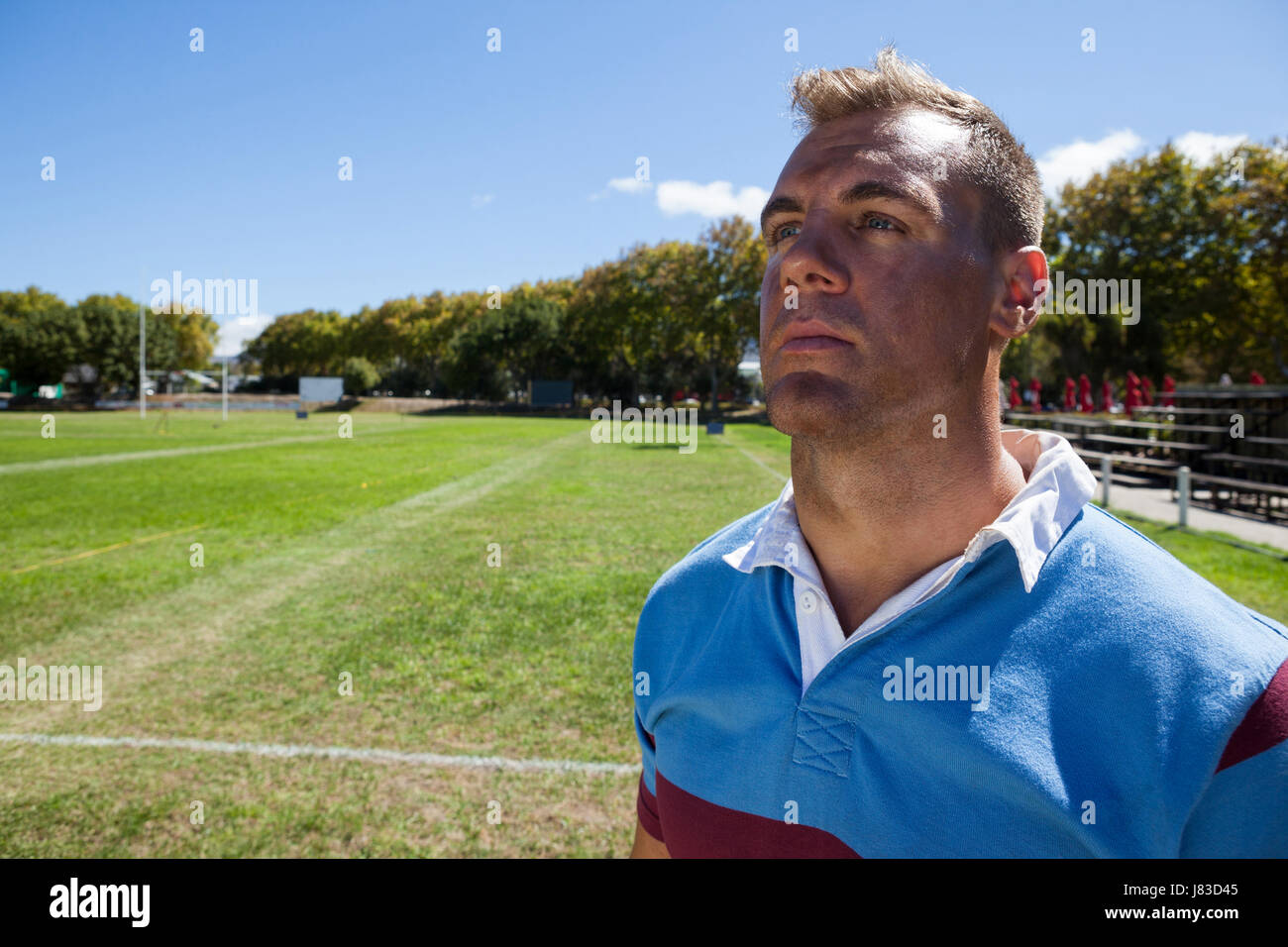 Thoughtful rugby player standing at playing field on sunny day Stock ...