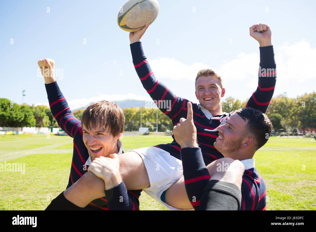 Portrait of happy rugby players enjoying at field on sunny day Stock ...