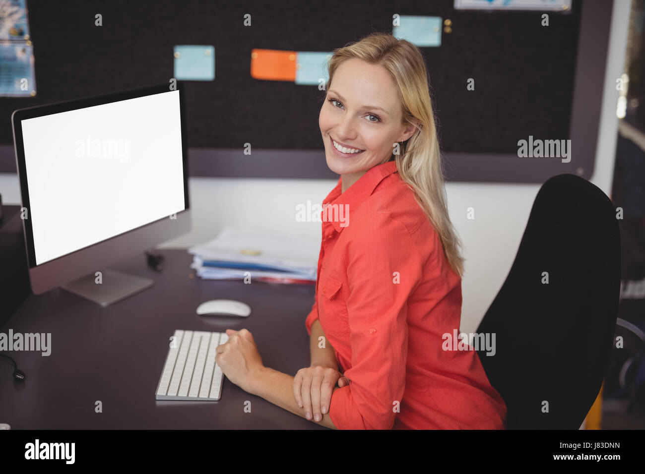 Portrait of smiling teacher sitting at desk in school Stock Photo - Alamy