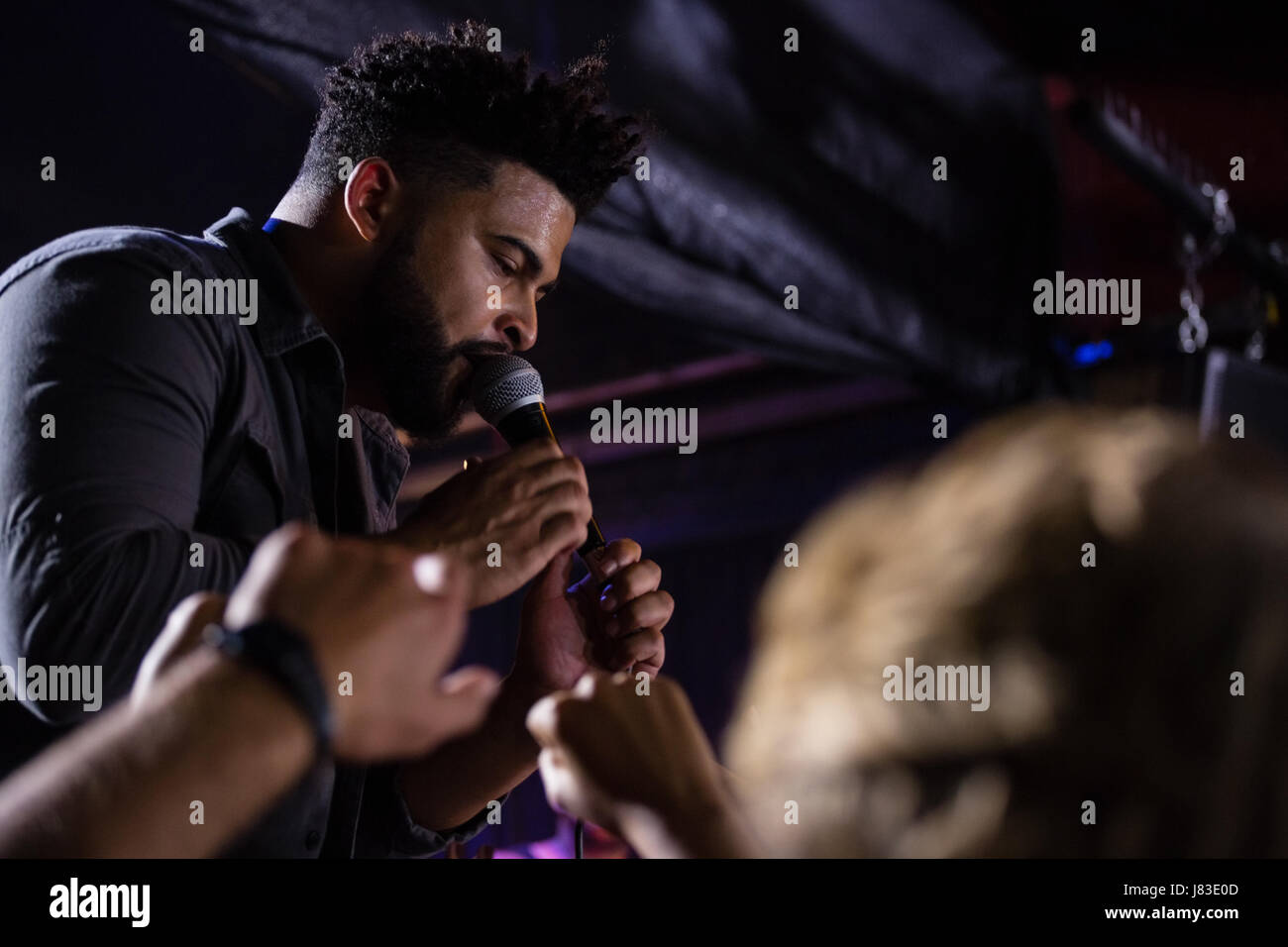 Singer performing on stage in nightclub Stock Photo - Alamy
