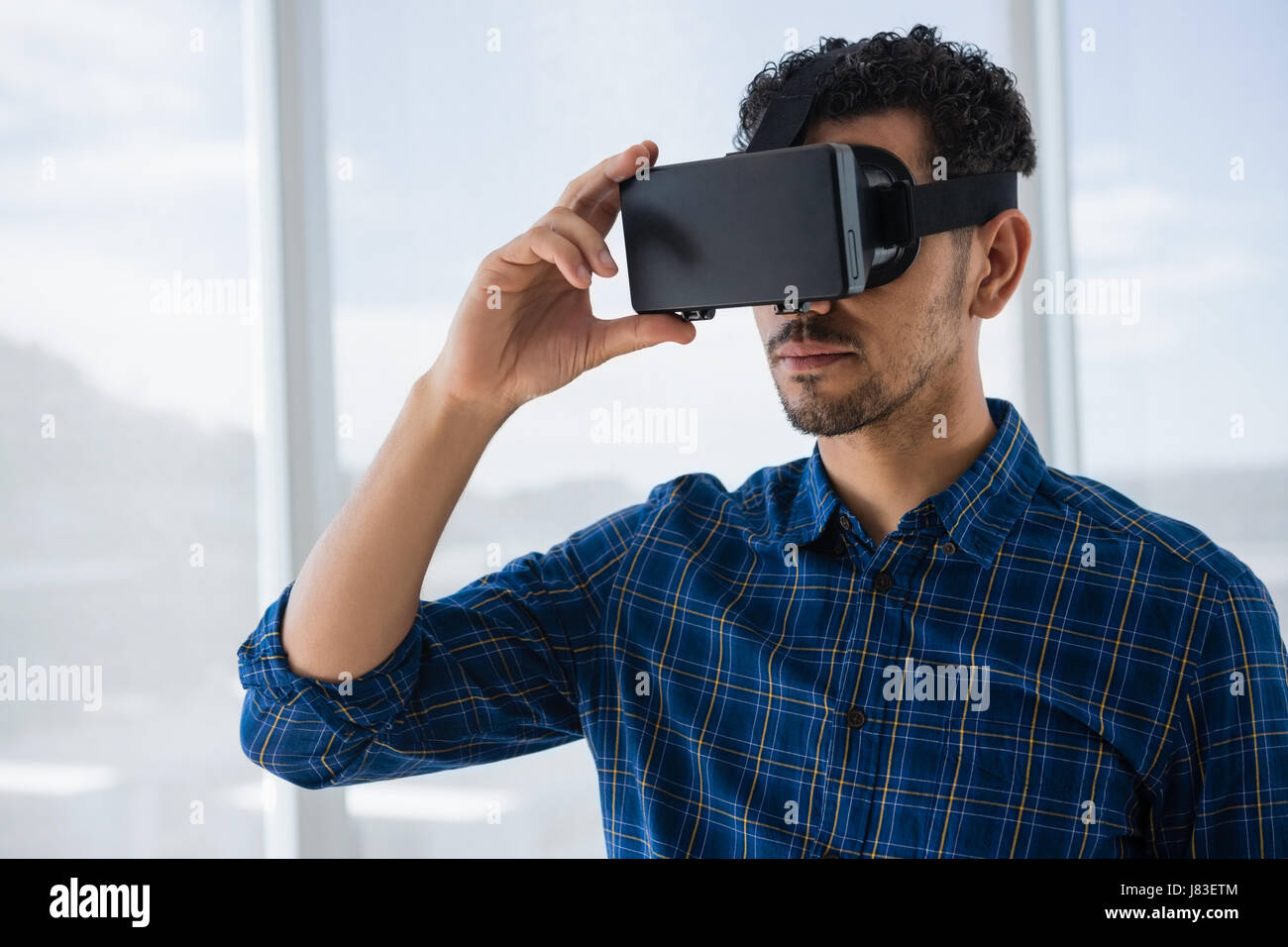 Executive using virtual reality headset in office Stock Photo - Alamy