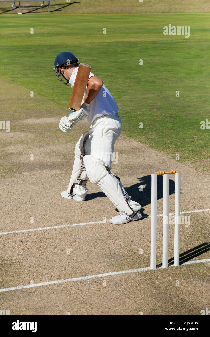 Side view of cricket player practicing on field during sunny day Stock ...