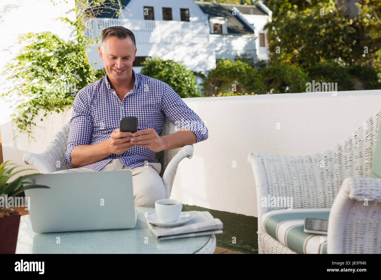 Happy man using mobile phone while sitting on chair at cafe Stock Photo ...