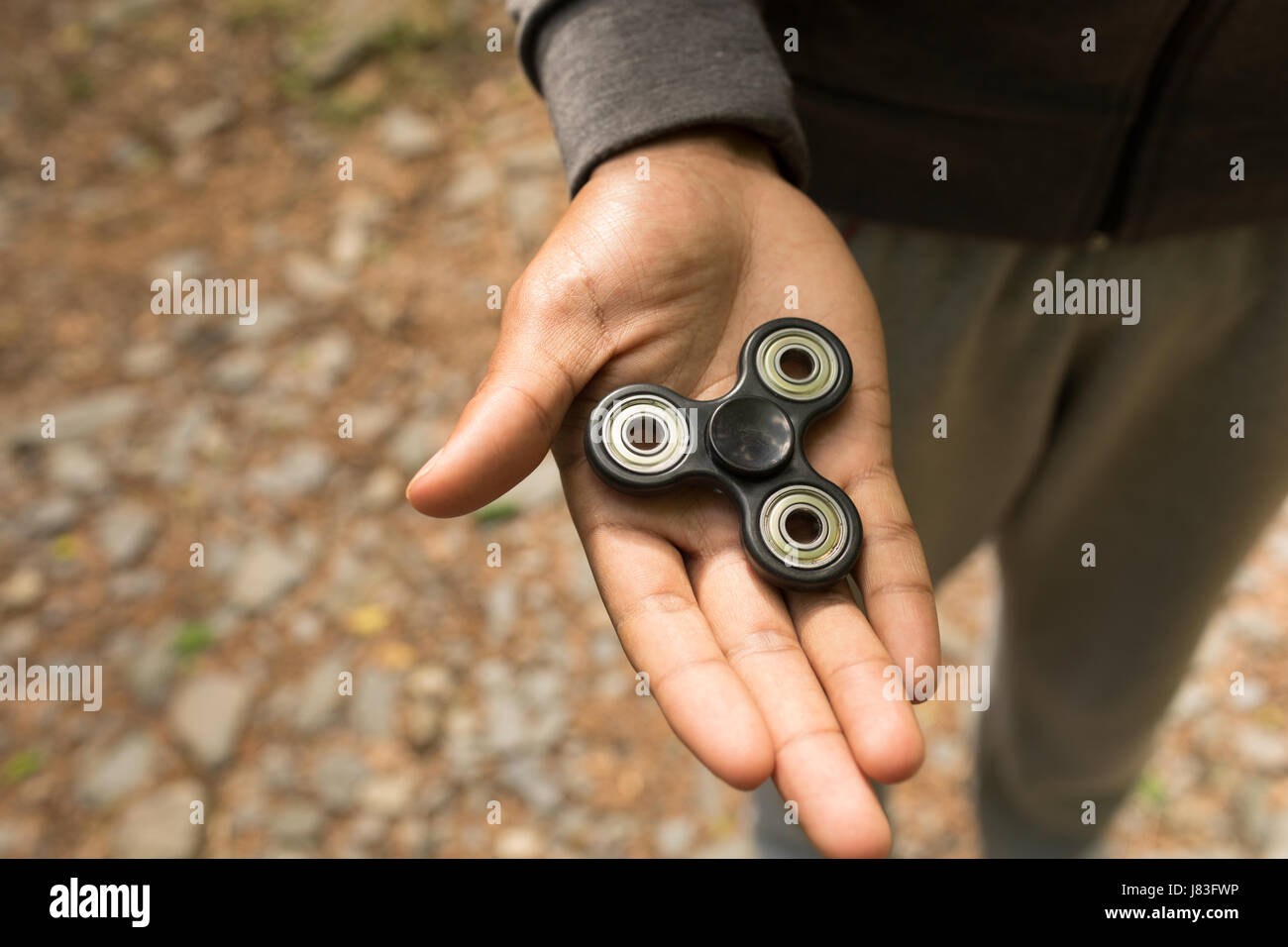 Close-up of a hand s man holding a fidget spinner Stock Photo - Alamy