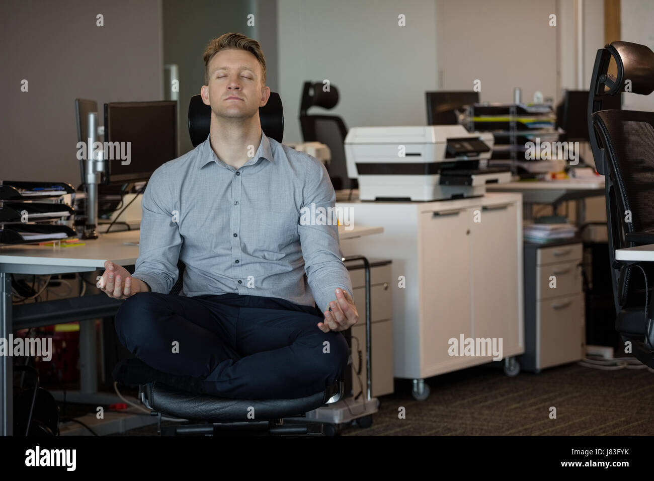 Executive meditating at desk in office Stock Photo - Alamy