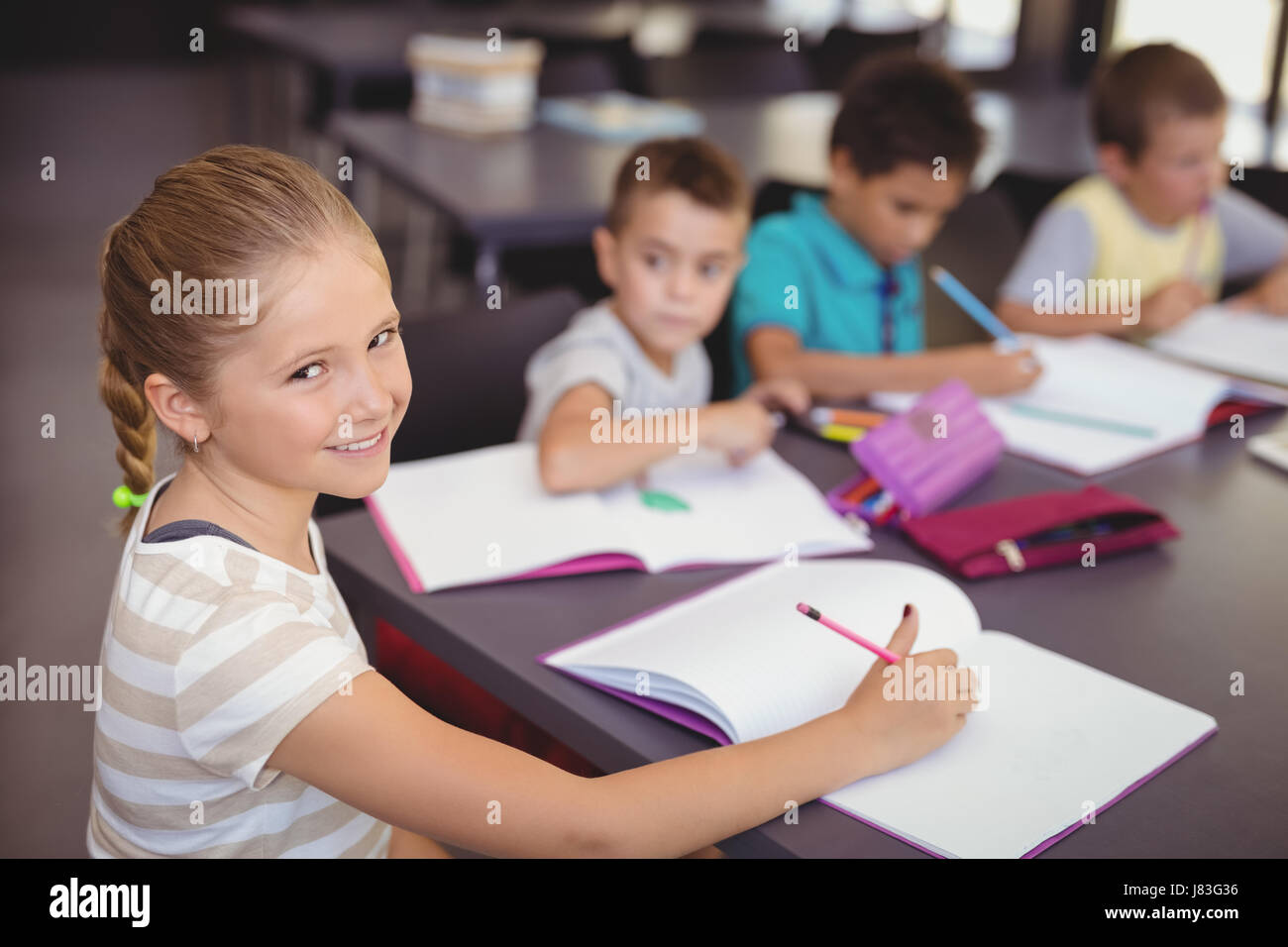 Smiling schoolkids doing their homework in library at school Stock ...