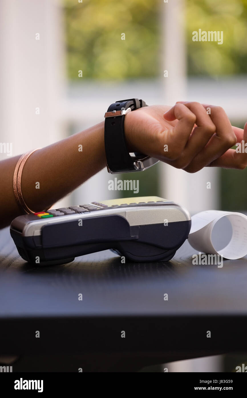 Cropped hand of customer making payment via smart watch in cafe Stock ...