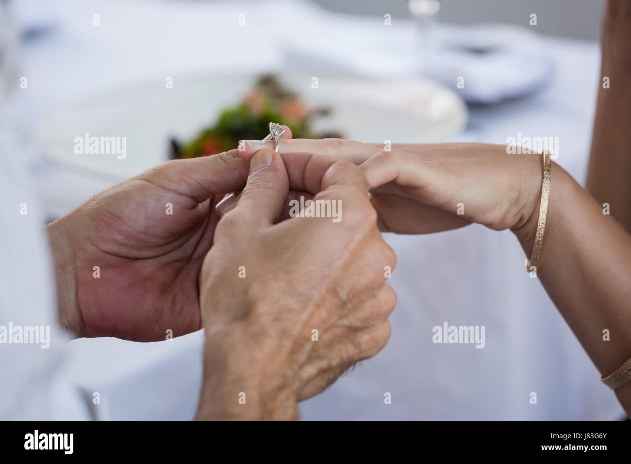 Cropped hands of man proposing woman Stock Photo - Alamy