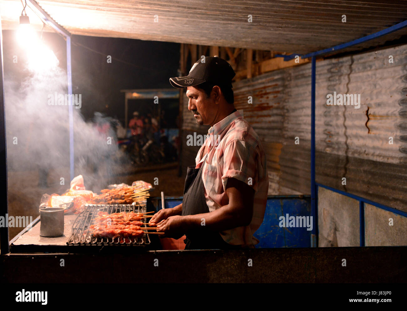 A street vendor mans a meat stand during a bull festival in Nicoya in ...