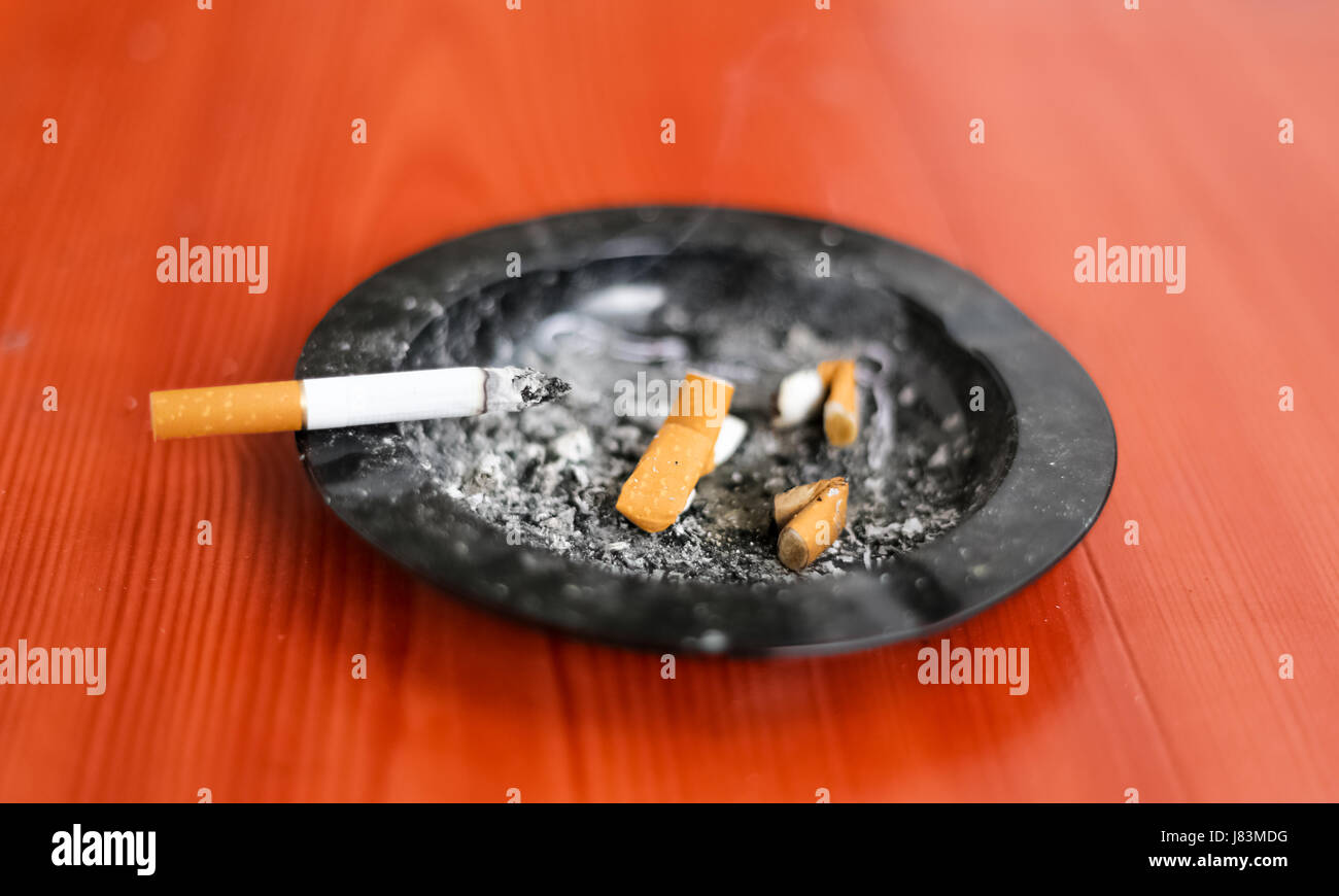 Burning cigarette in the ashtray, among OFF, tranquilizers with cigars ...