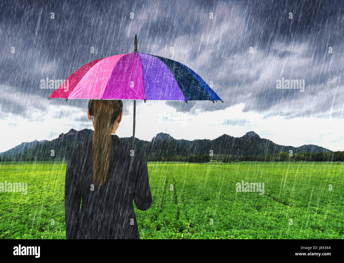 business woman holding multicolored umbrella with falling rain at Khao ...