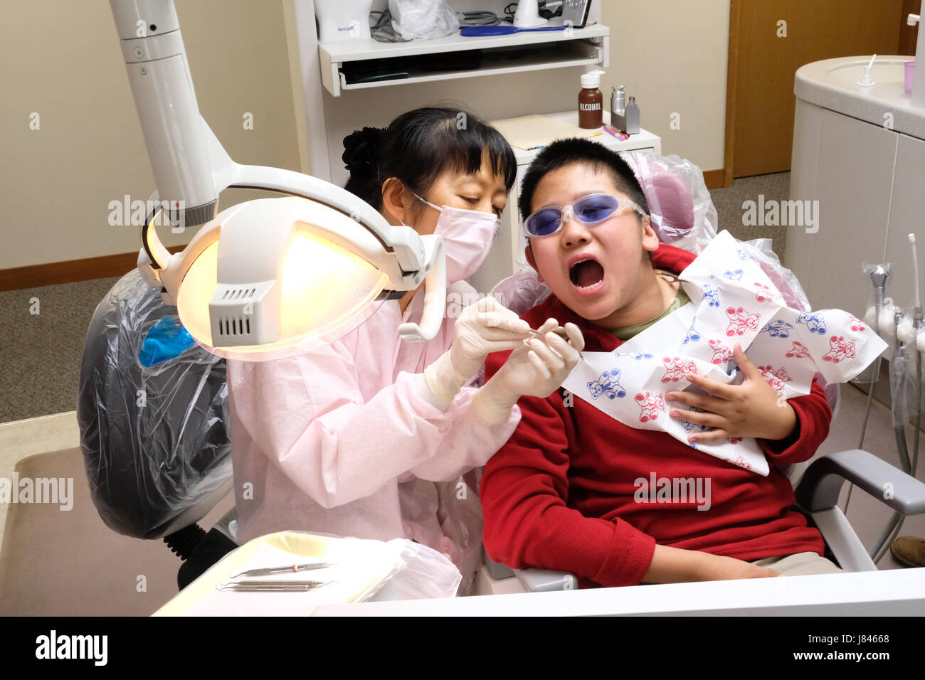 A young Asian boy got his teeth cleaned by a female dentist Stock Photo ...