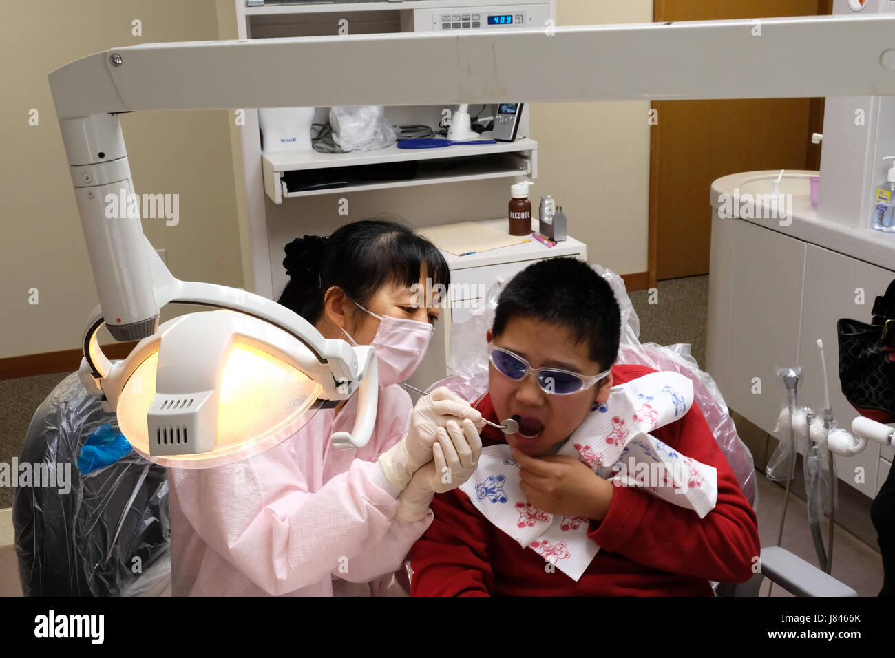 A young Asian boy got his teeth cleaned by a female dentist Stock Photo ...
