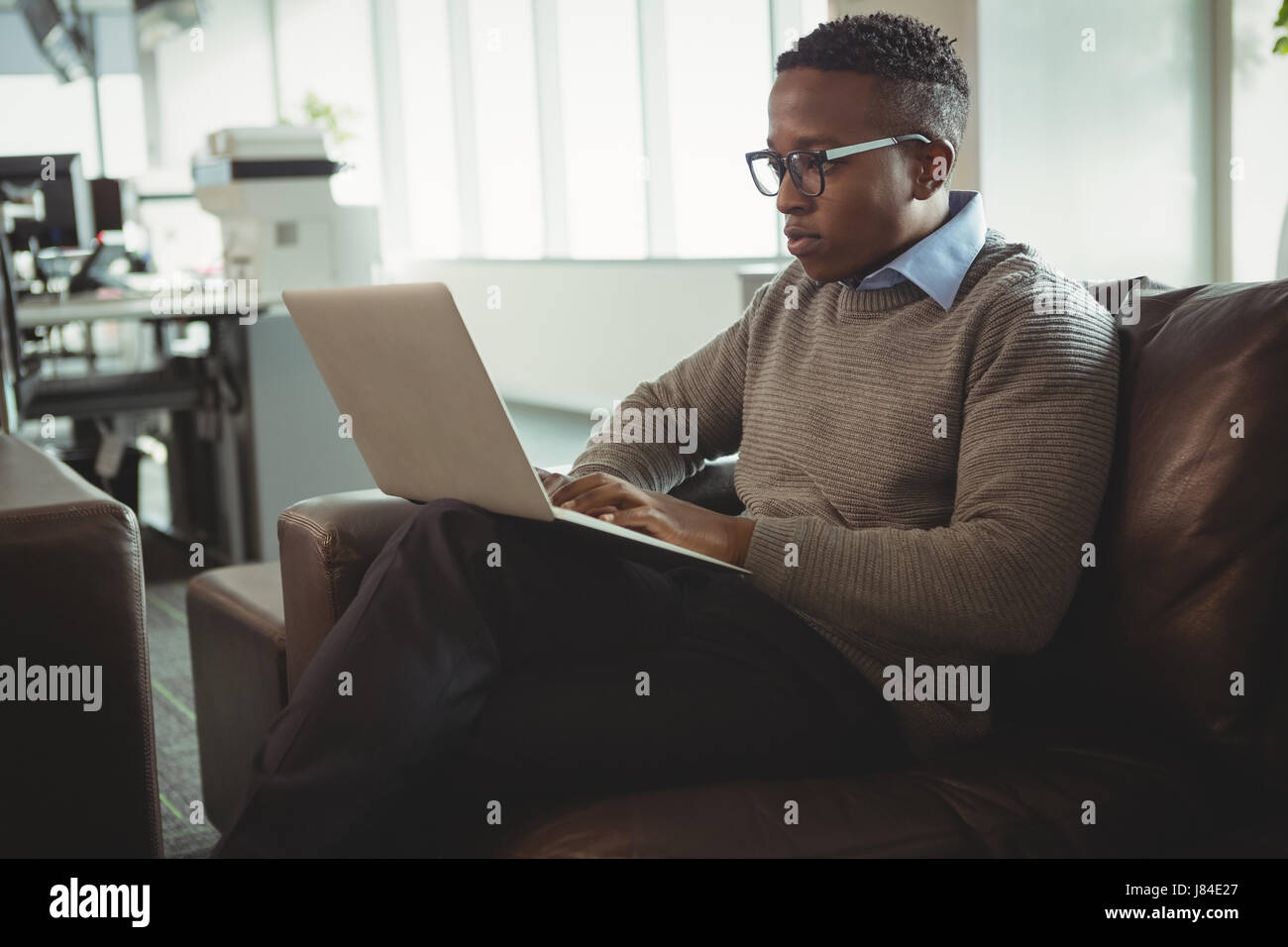 Male executive using laptop in office Stock Photo - Alamy