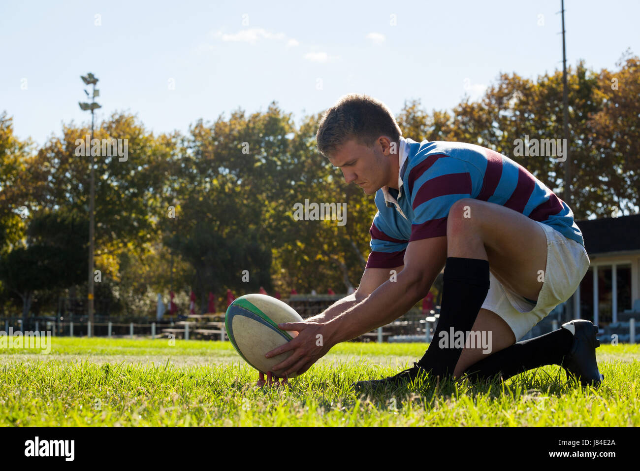 Side view of rugby player getting ready to kick for goal on playing ...