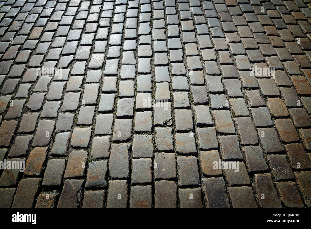 Antique cobblestone road shined bright sun. Background Stock Photo - Alamy