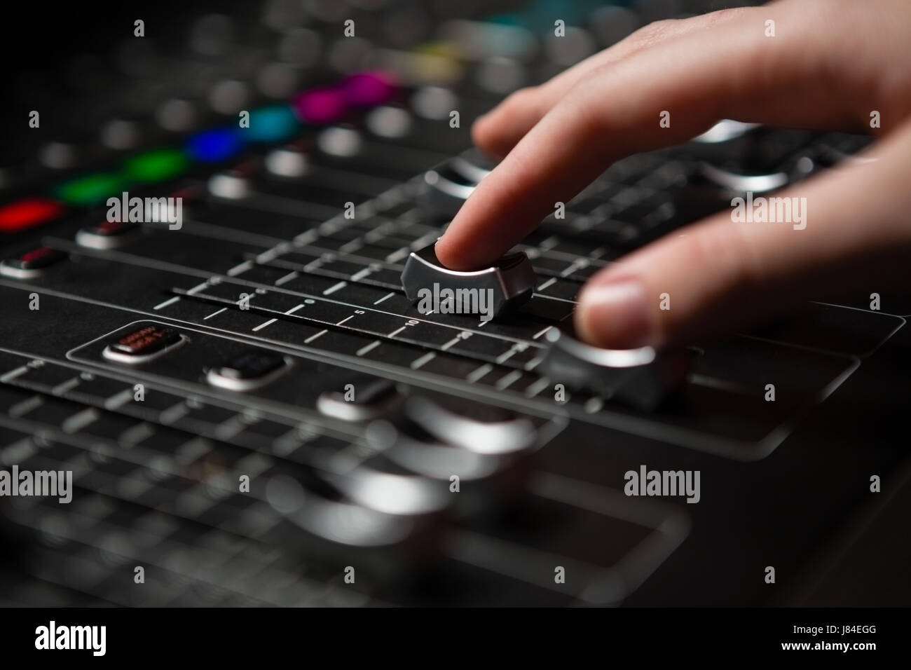 Hand of female audio engineer using sound mixer in recording studio ...