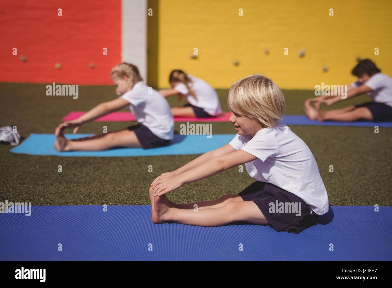 Schoolkids performing stretching exercise in schoolyard Stock Photo - Alamy