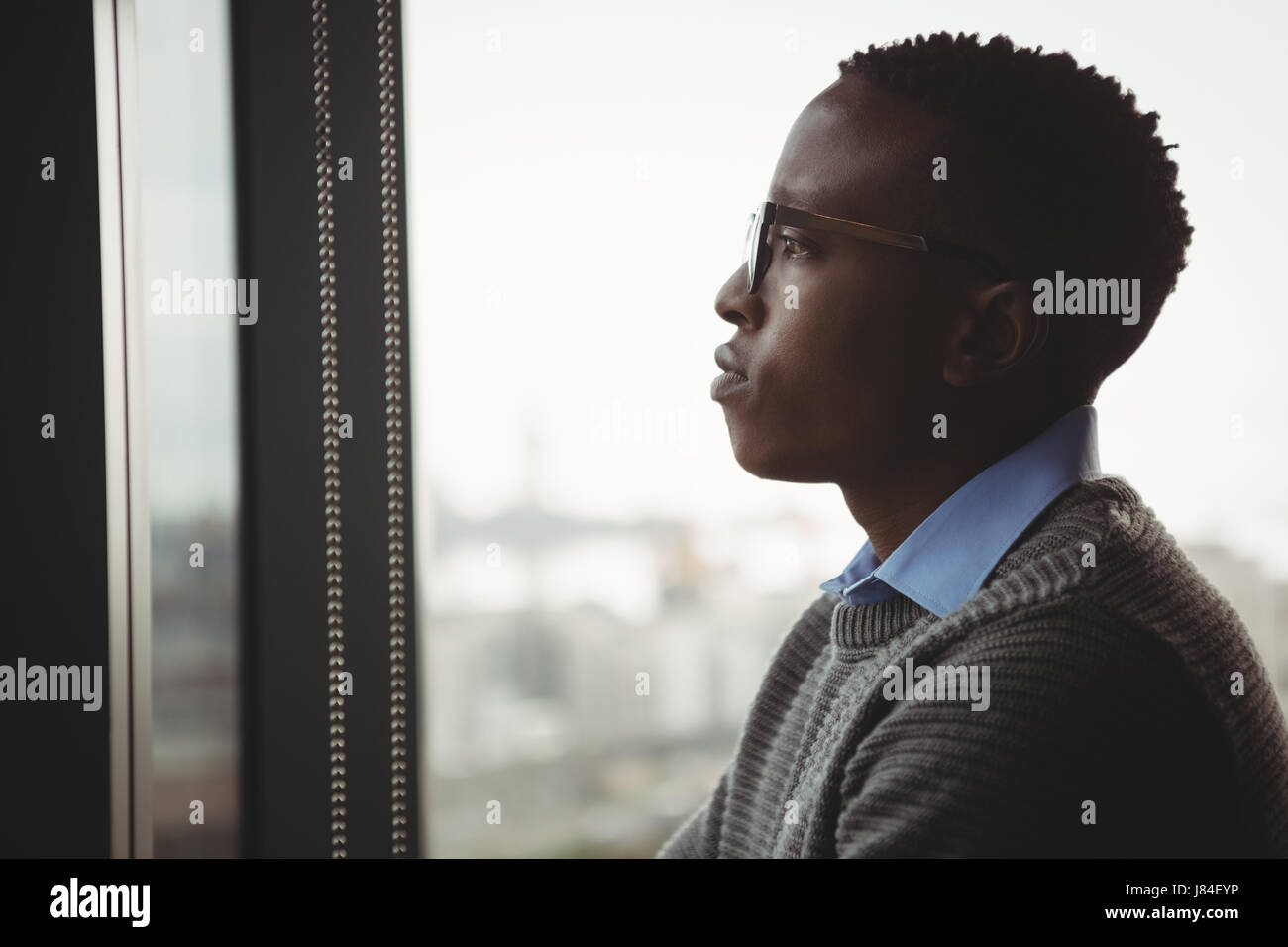 Thoughtful executive looking through window in office Stock Photo - Alamy