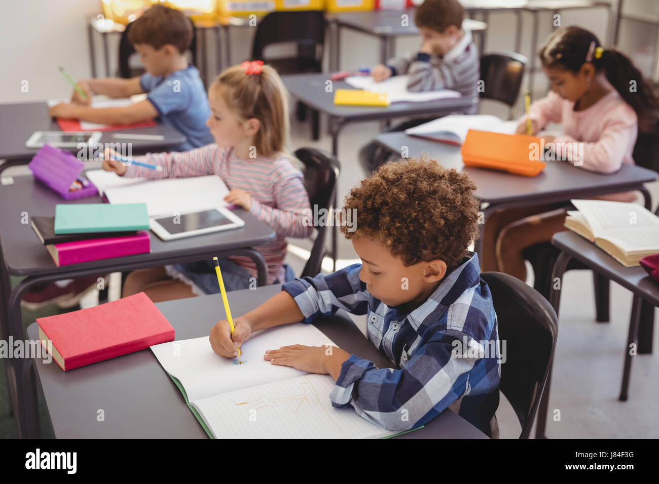 Attentive schoolkids doing their homework in classroom at school Stock ...