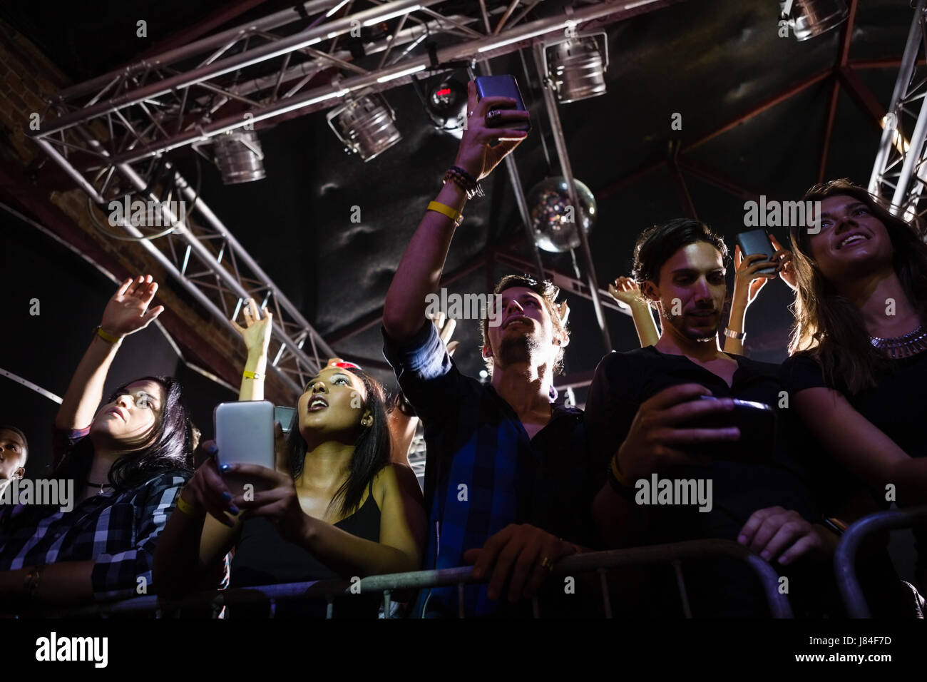 Crowd watching and taking photograph of performer in nightclub Stock ...