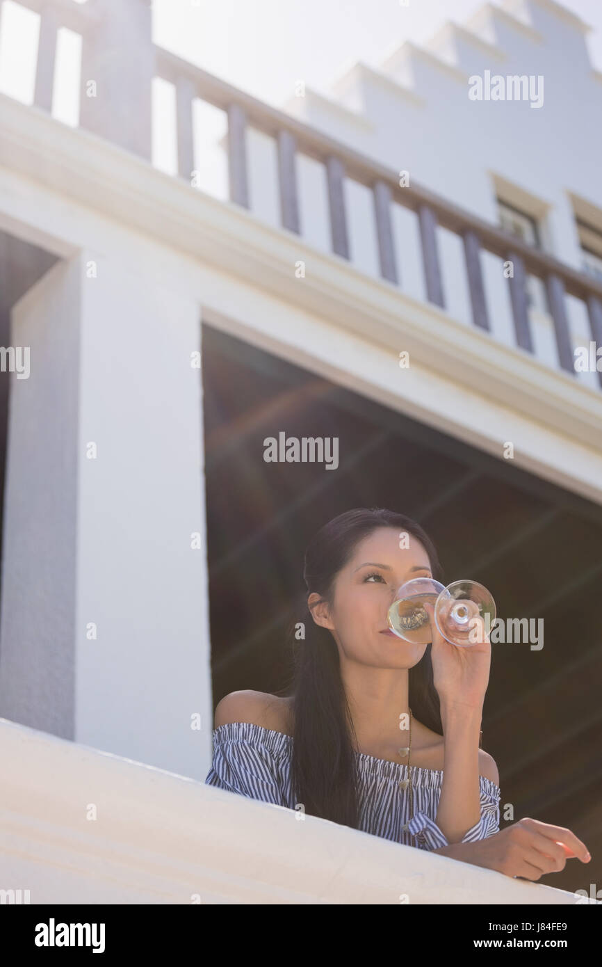 Low angle view of thoughtful woman drinking white wine in restaurant ...