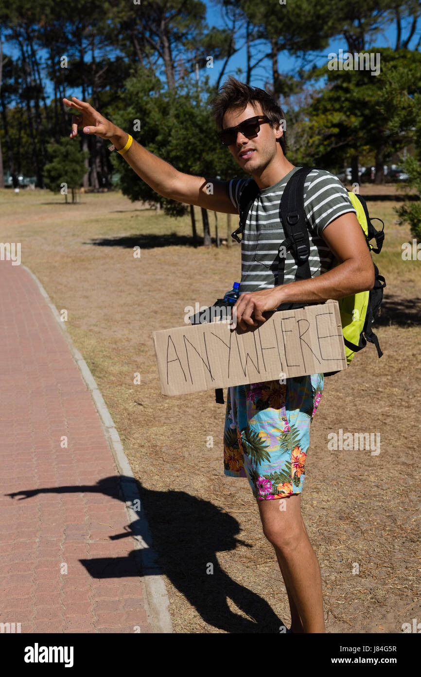 Young man hitchhiking roadside hi-res stock photography and images - Alamy