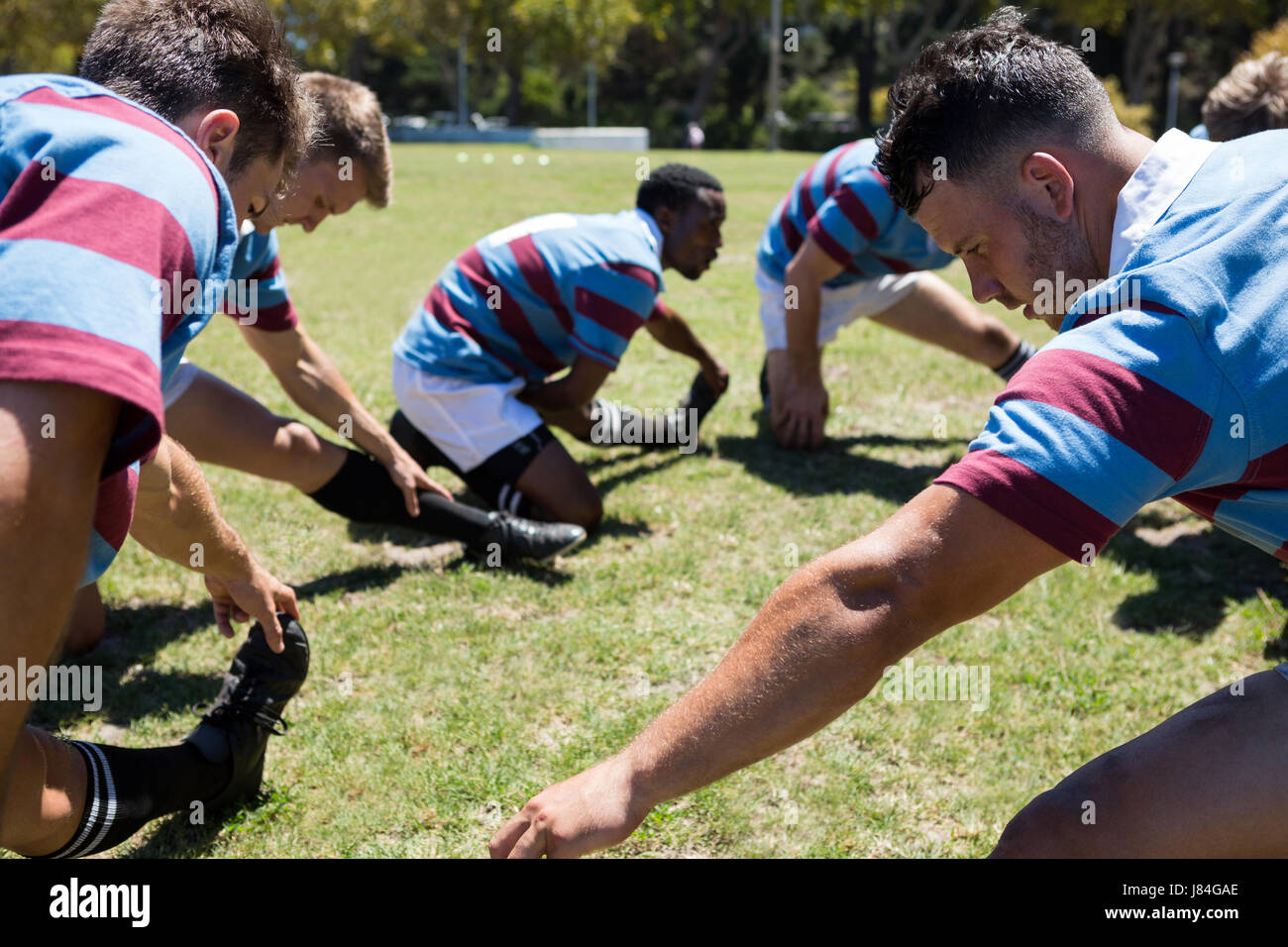Close up of rugby players touching toes at field on sunny day Stock ...