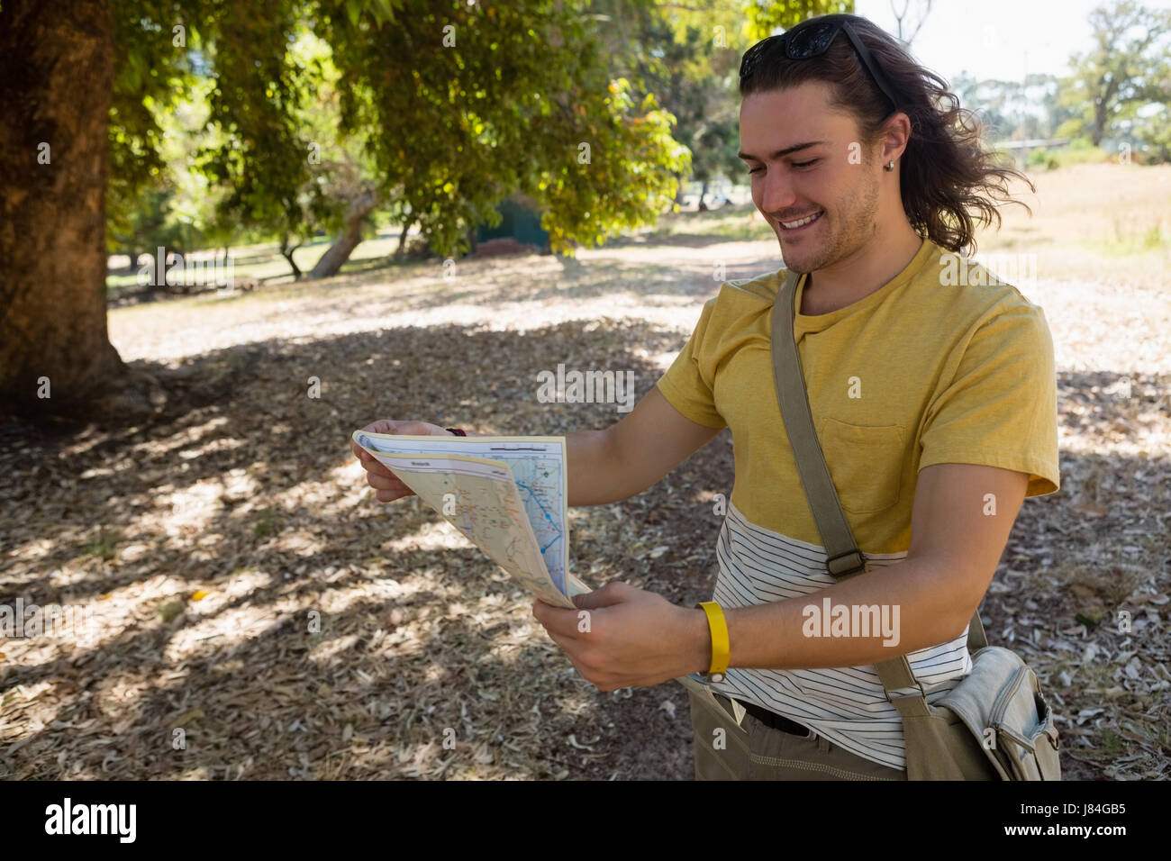 Tourist man looking at map in the park on a sunny day Stock Photo - Alamy