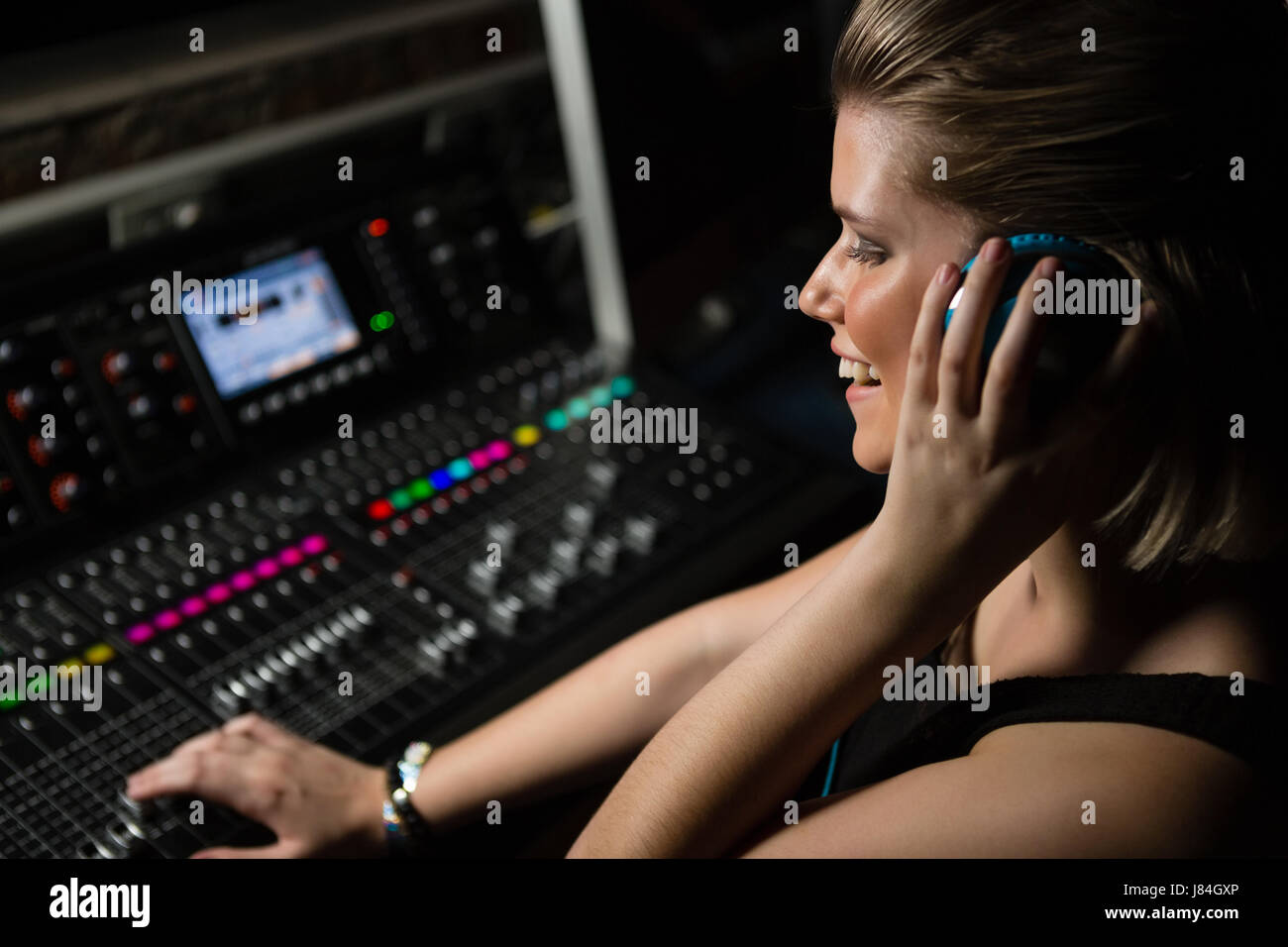 Female audio engineer using sound mixer in recording studio Stock Photo ...