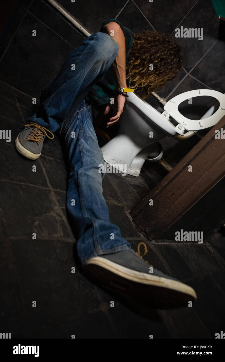 Man vomiting on toilet bowl in the washroom Stock Photo - Alamy