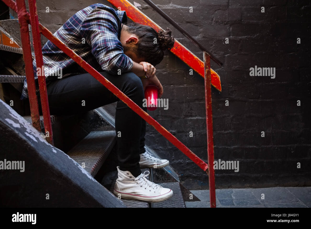 Drunk man sitting on staircase of bar Stock Photo - Alamy