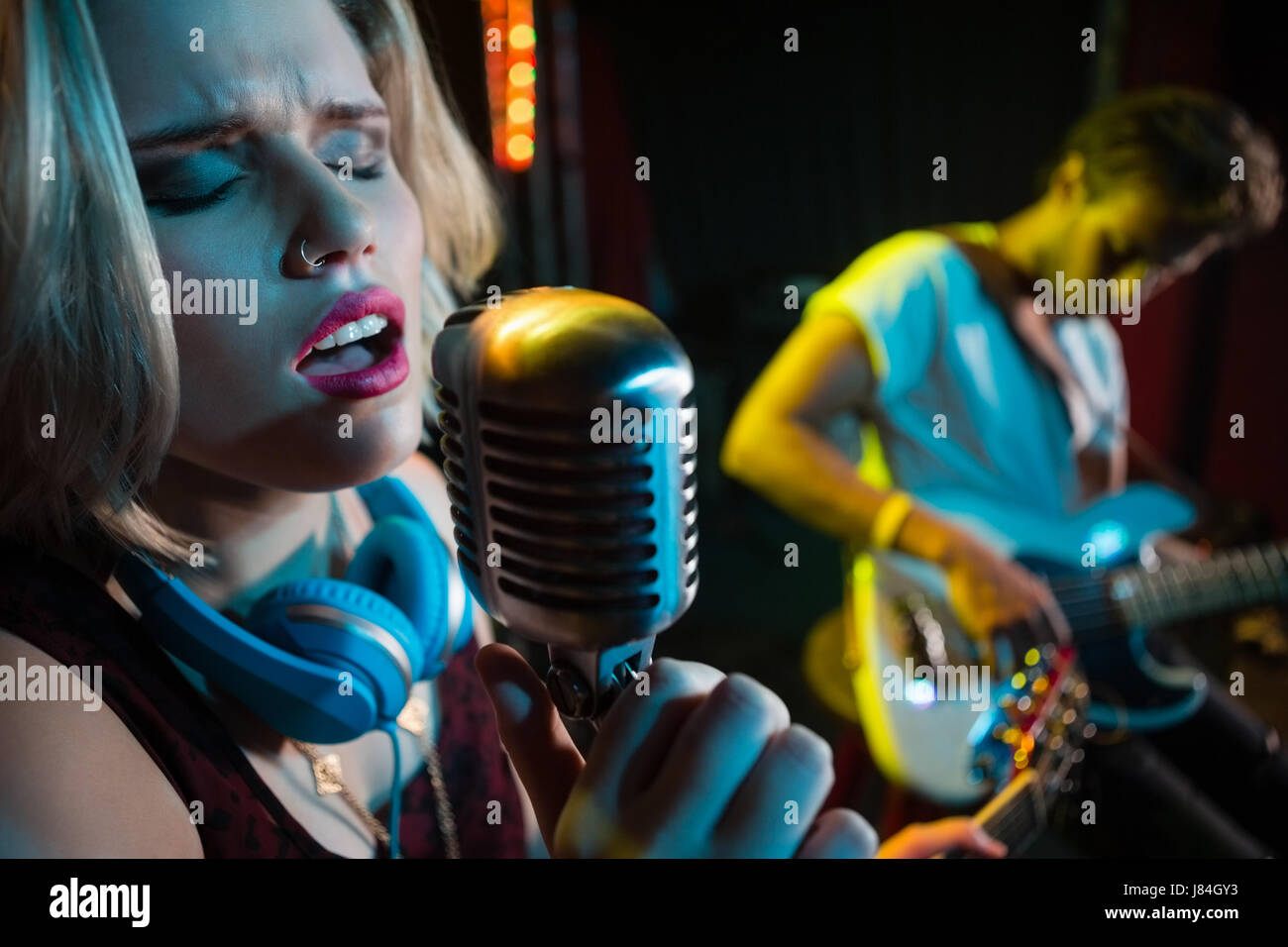 Female singer singing on vintage microphone in nightclub Stock Photo ...