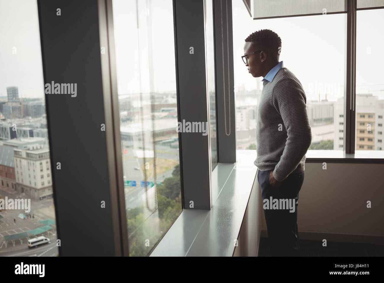 Thoughtful executive looking through window in office Stock Photo - Alamy