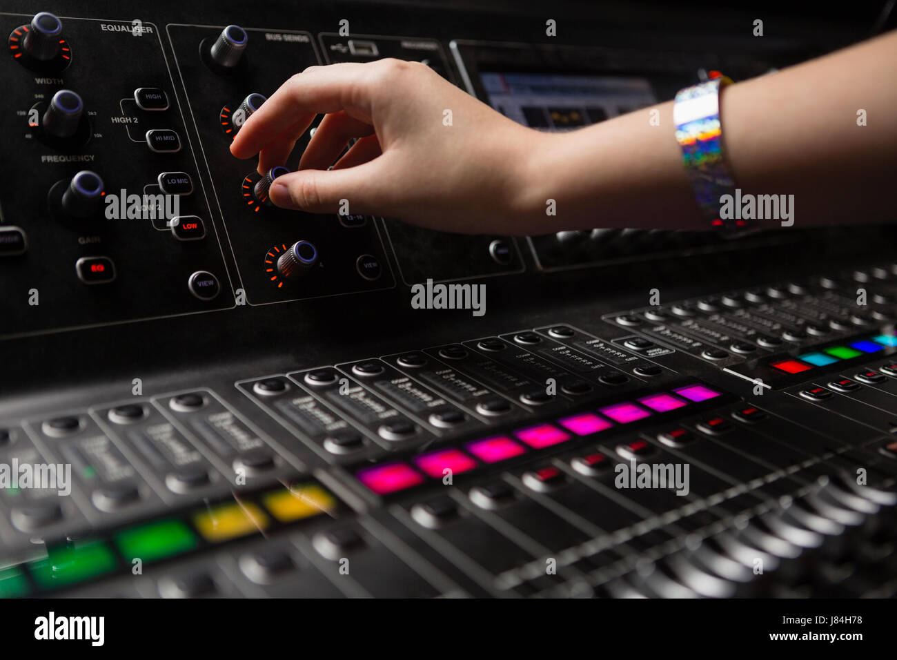Hand of female audio engineer using sound mixer in recording studio ...