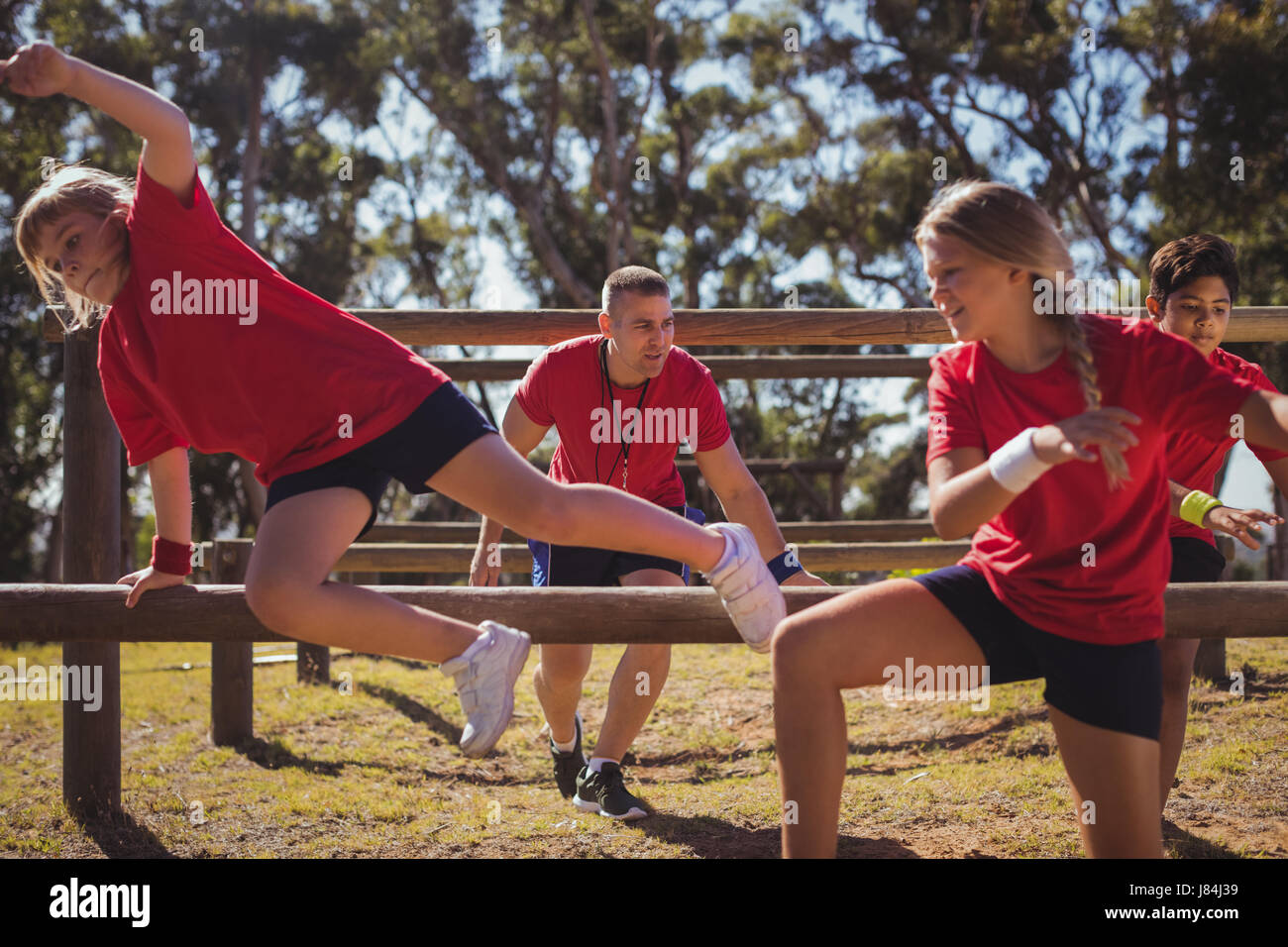 Trainer instructing kids during obstacle course training in the boot ...