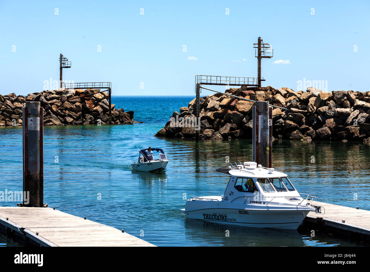 Fishing boats enter Lonsdale harbour through breakwater Stock Photo - Alamy